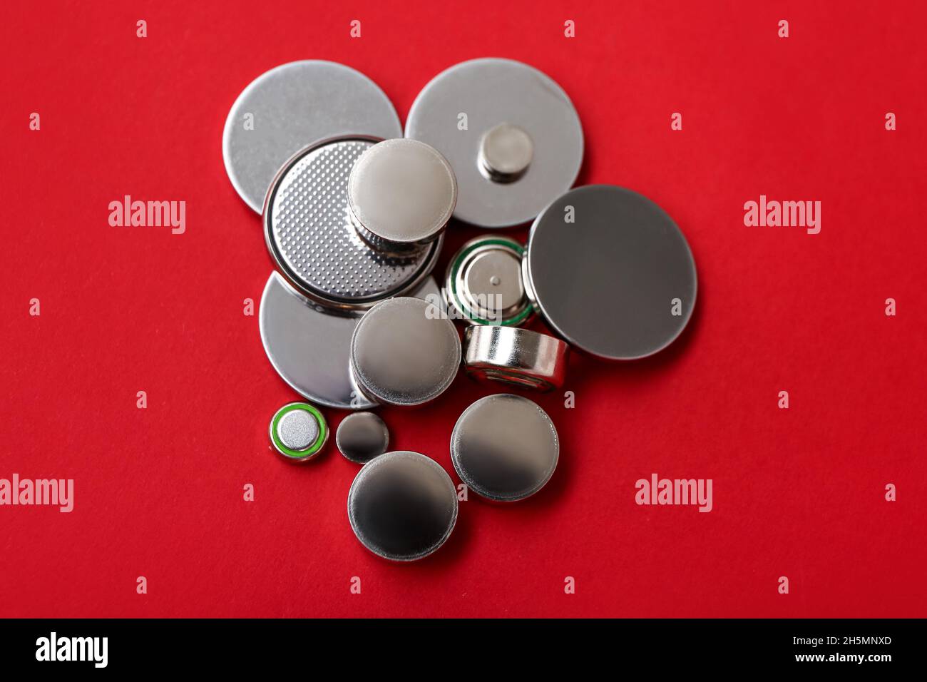 Lithium button cell batteries on red background Stock Photo - Alamy
