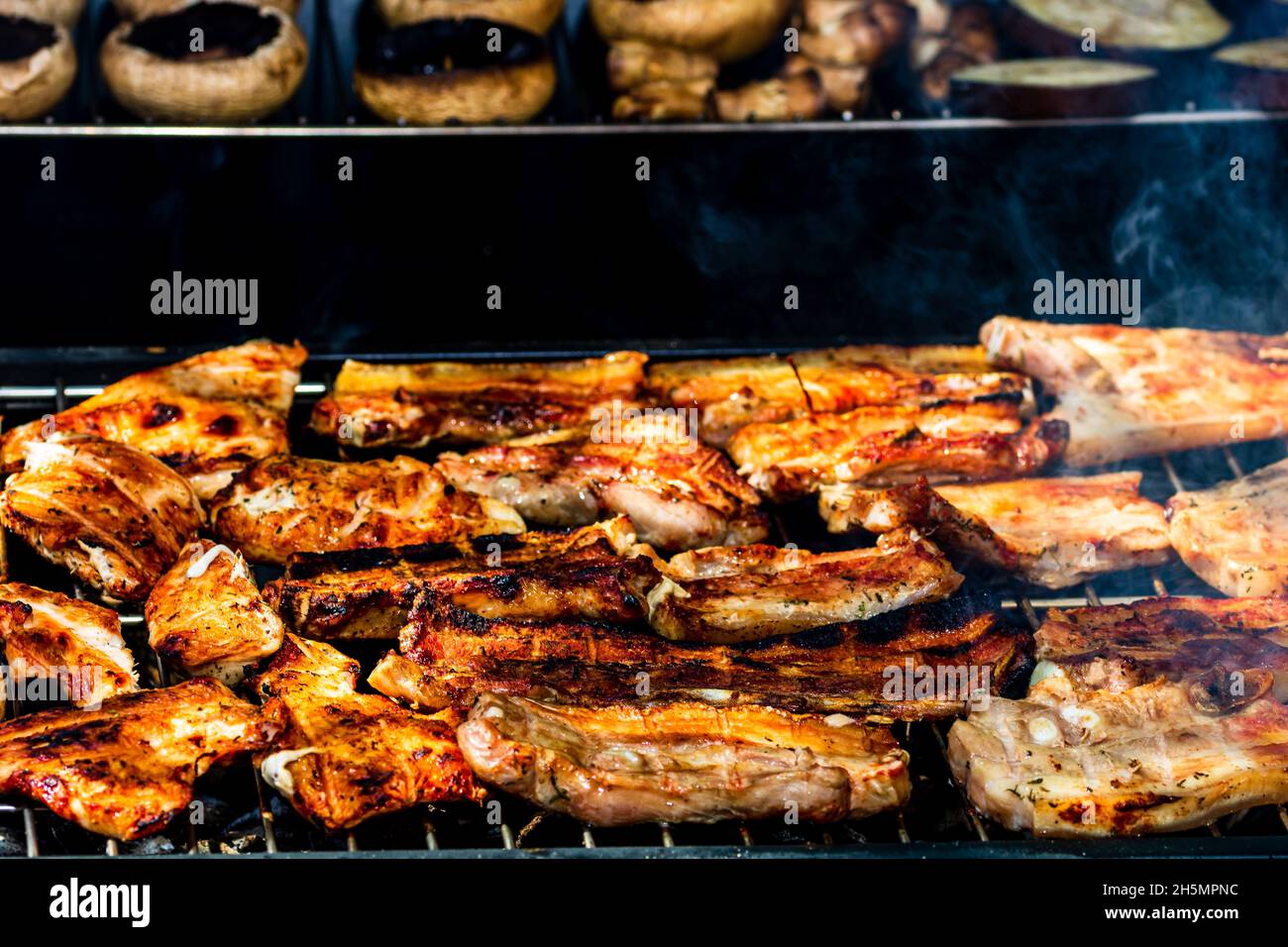Assorted delicious meats cooking on a grill Stock Photo - Alamy