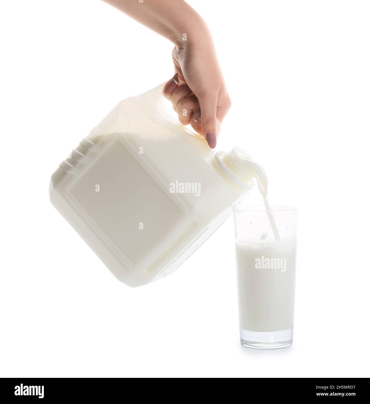 Woman pouring milk from gallon container into glass on white background ...