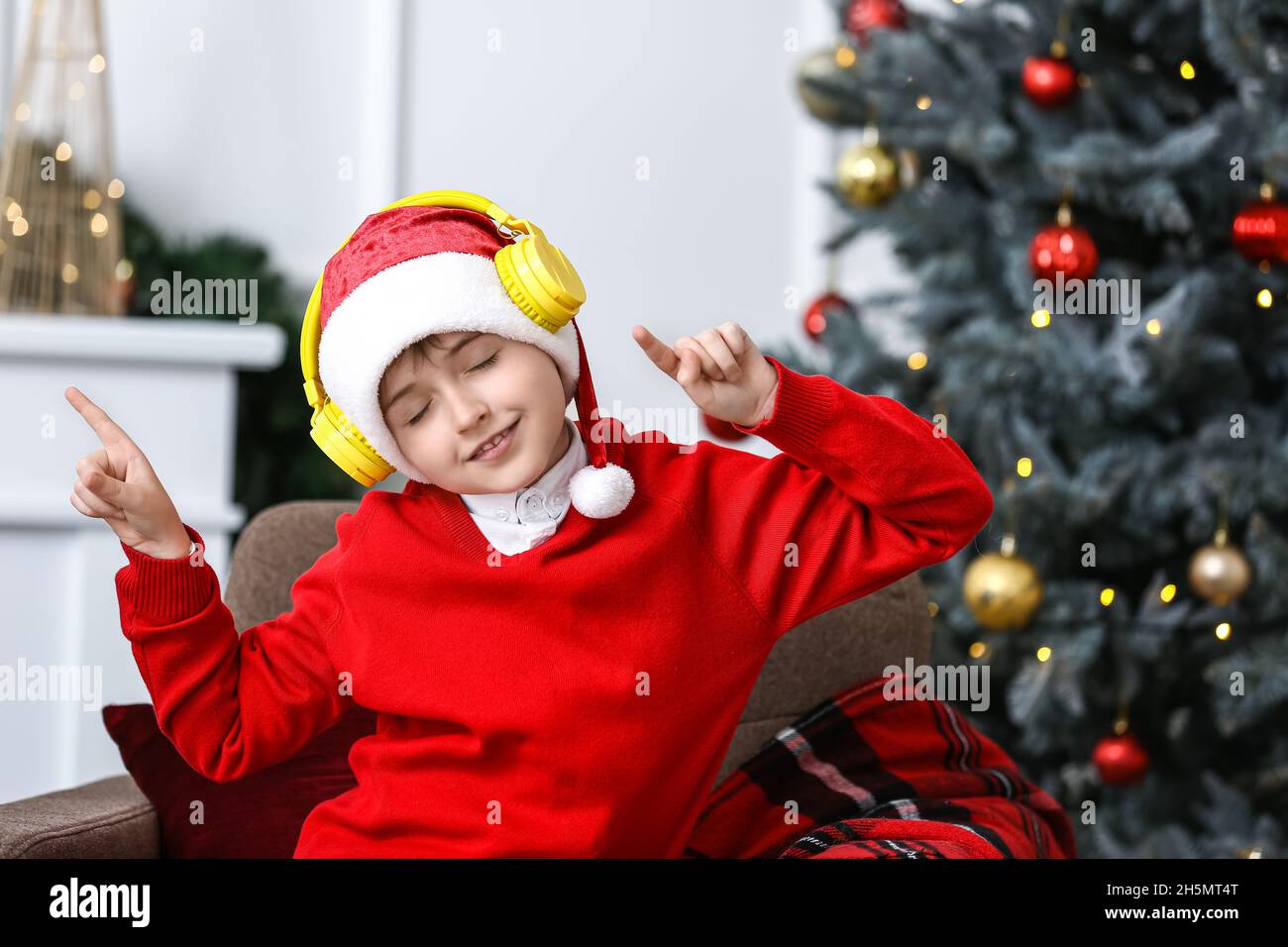 Little boy listening to Christmas music at home Stock Photo Alamy