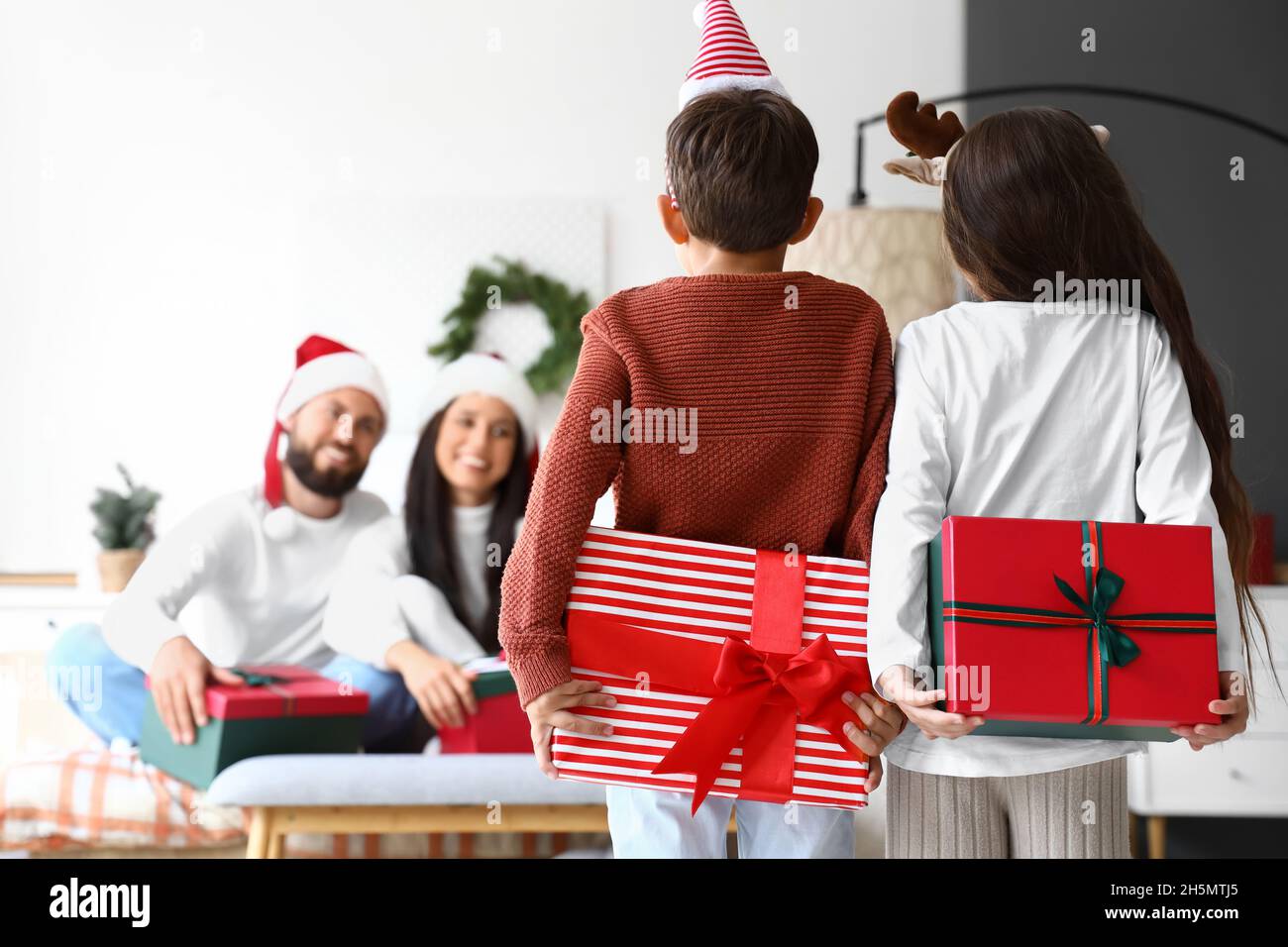 Little children hiding gifts for their parents at home on Christmas eve ...