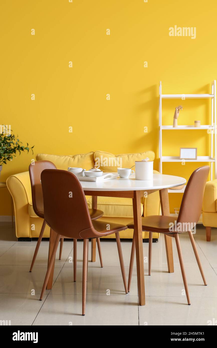 Interior of bright yellow dining room with table Stock Photo - Alamy