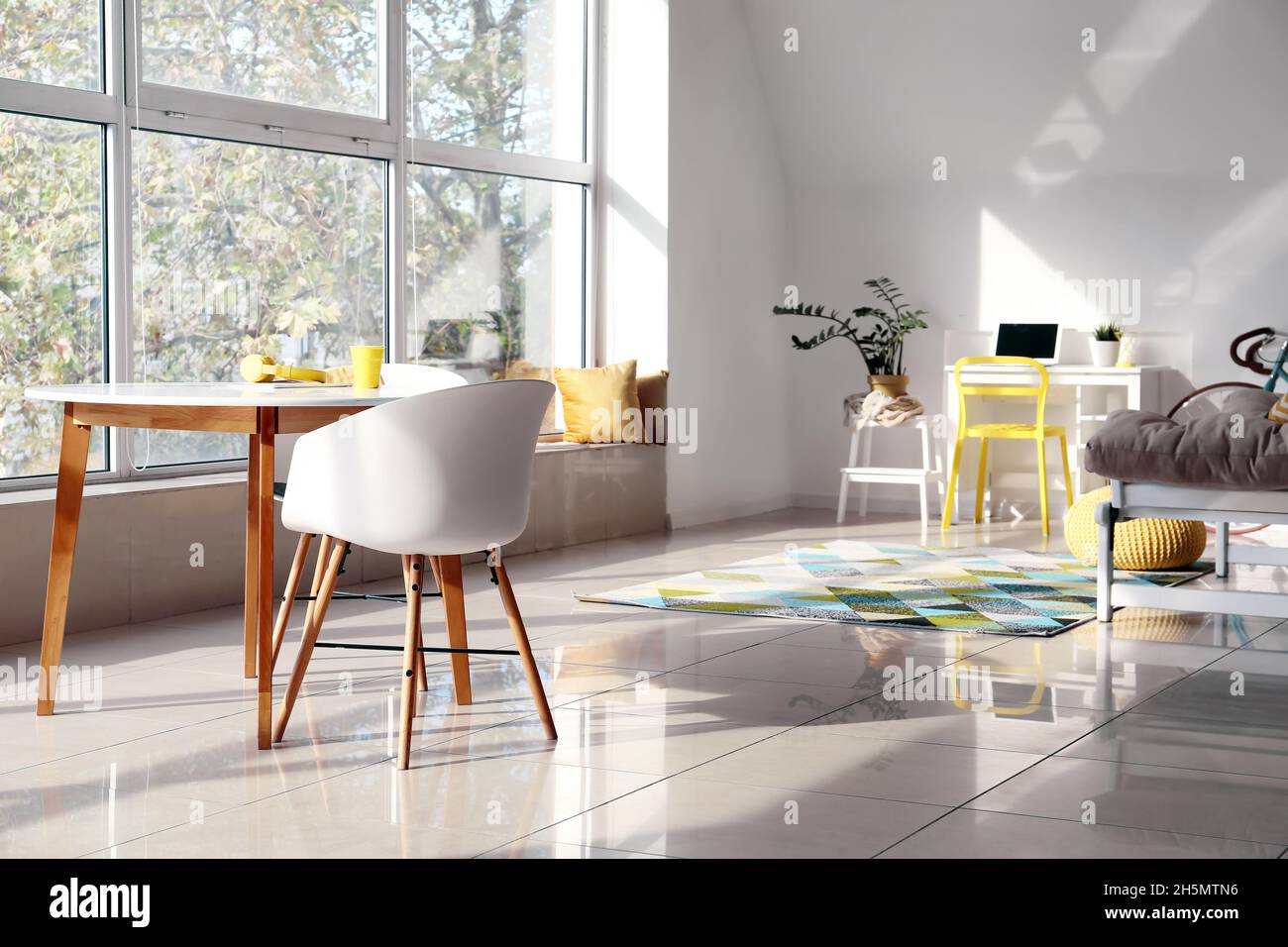 Interior of light dining room with big window and modern workplace ...