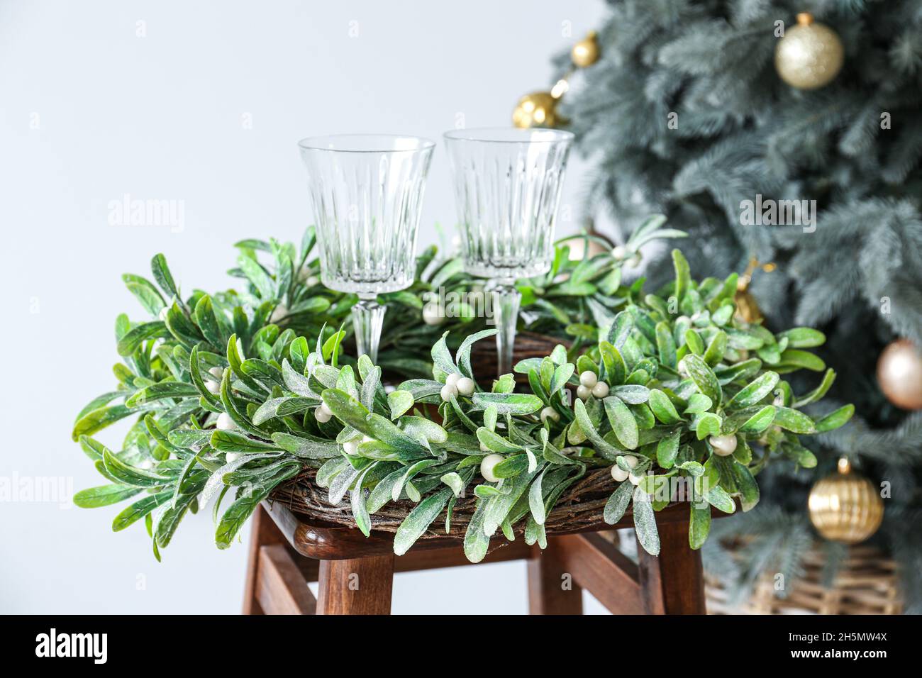 Beautiful mistletoe wreath with glasses on table in room Stock Photo ...