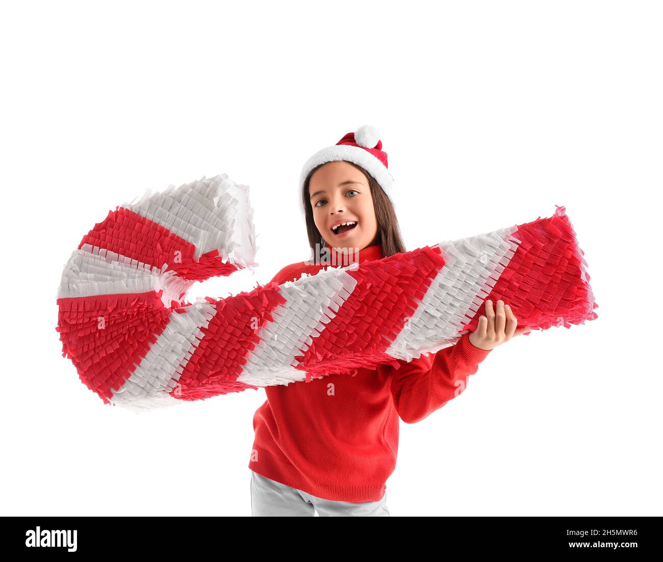 Little girl in Santa hat and with candy cane pinata on white background ...