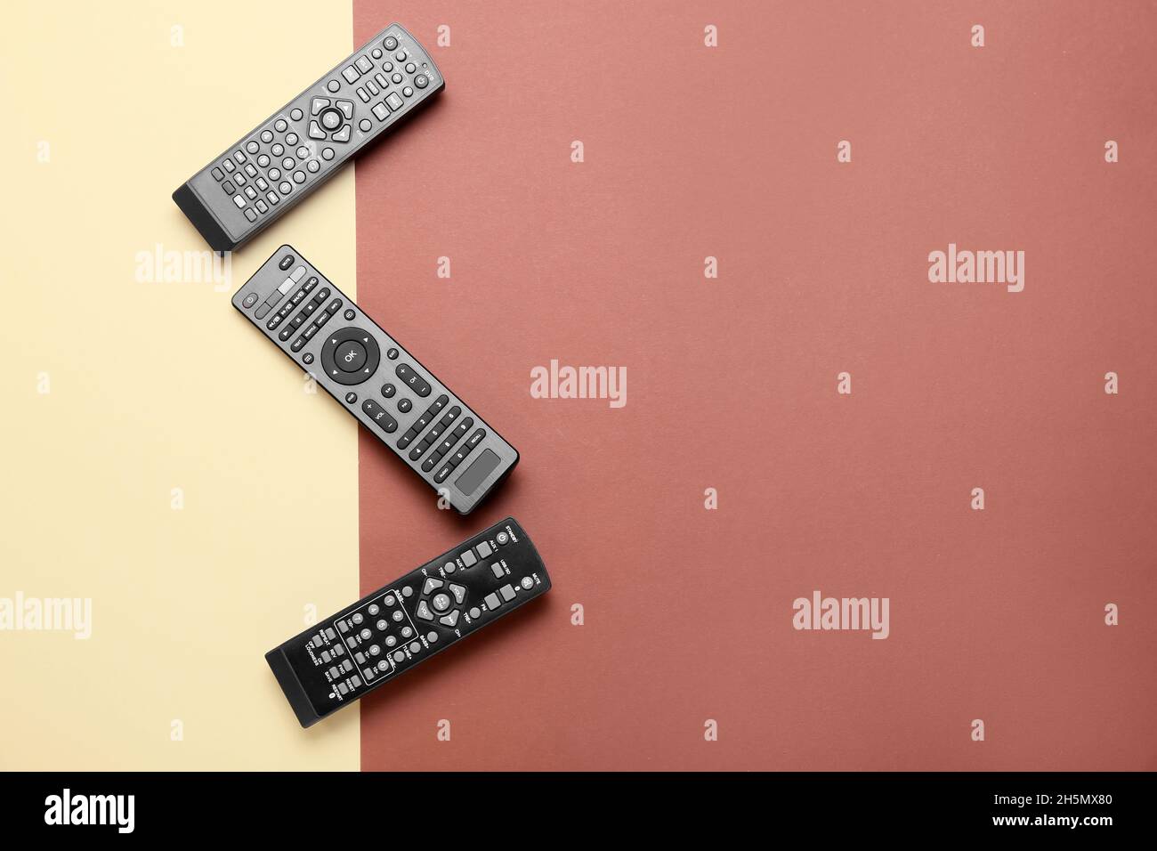 Different modern TV remote controllers on color background Stock Photo ...