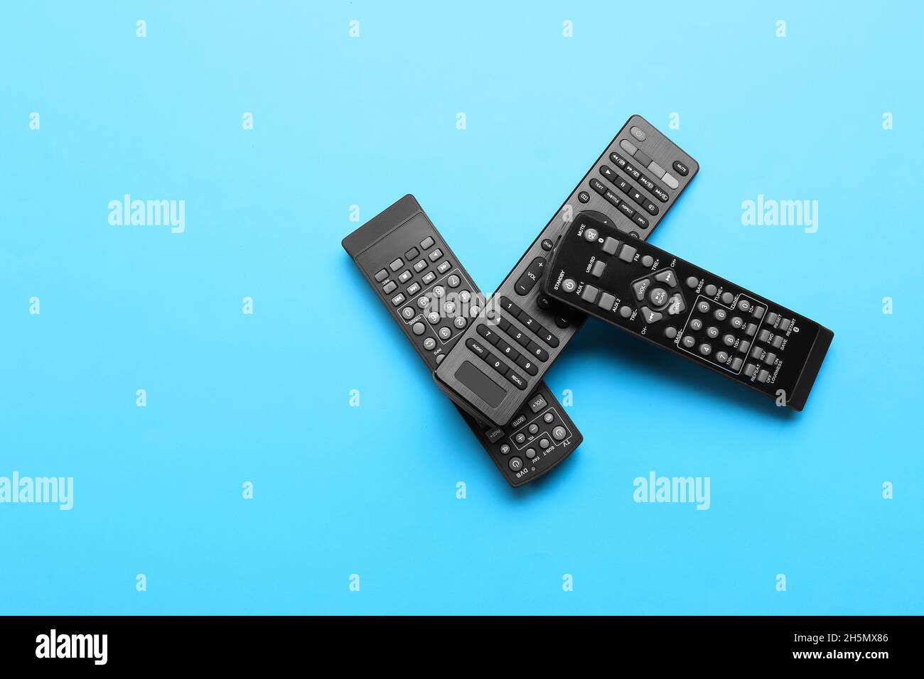 Different TV remote controllers on blue background Stock Photo - Alamy
