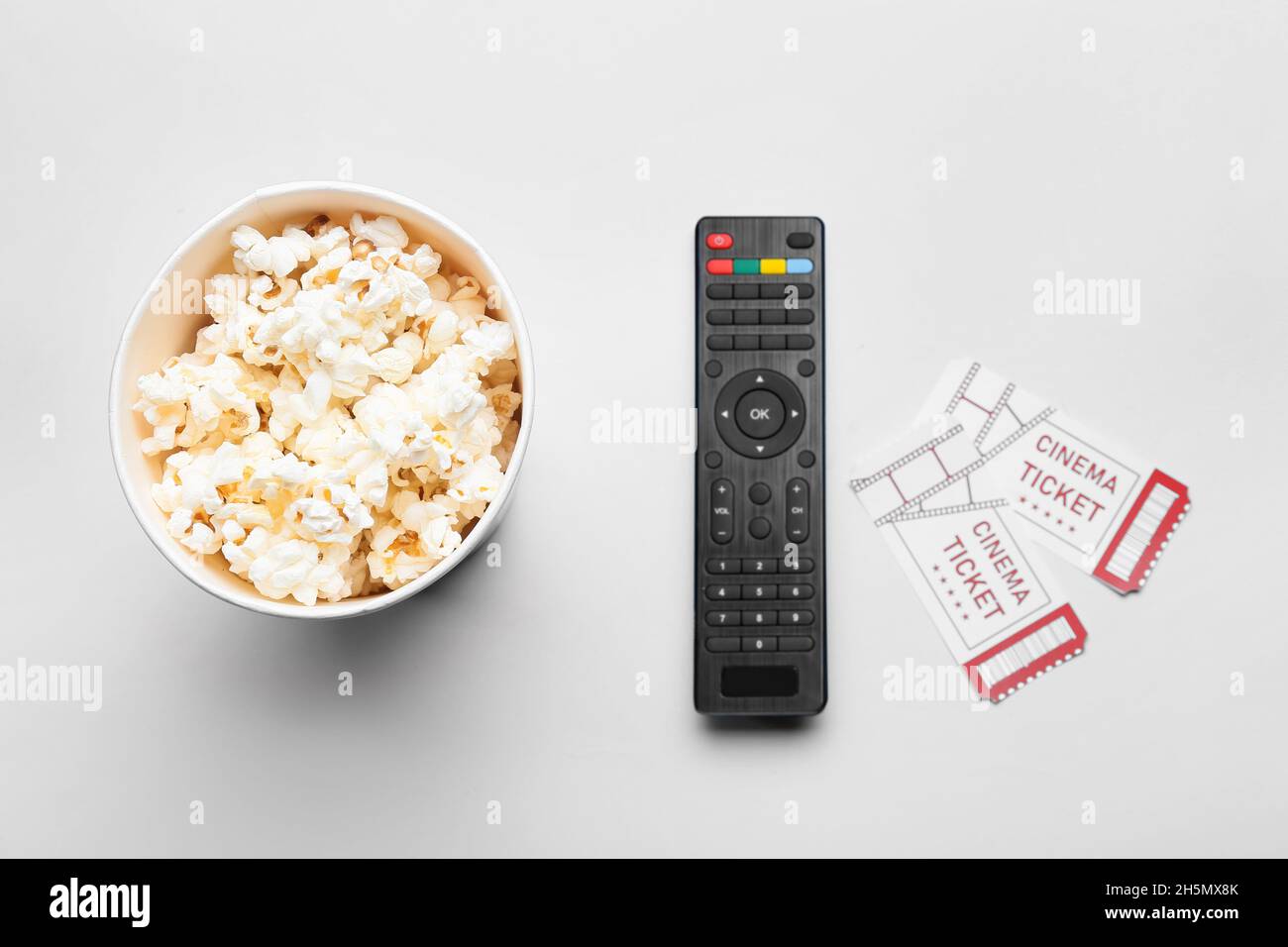 Modern TV remote control, bucket with popcorn and cinema tickets on ...