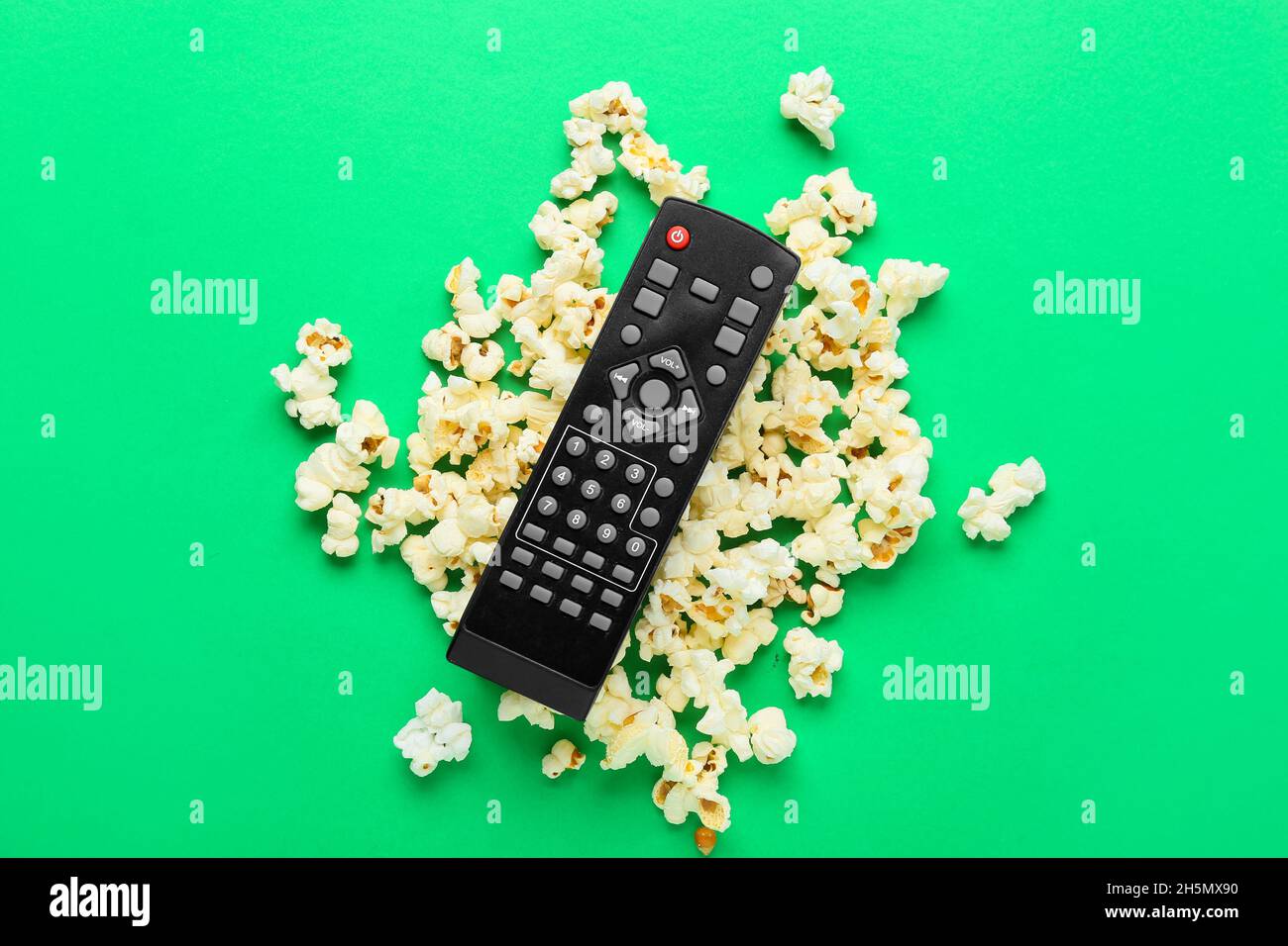 Modern TV remote control with popcorn on green background Stock Photo ...