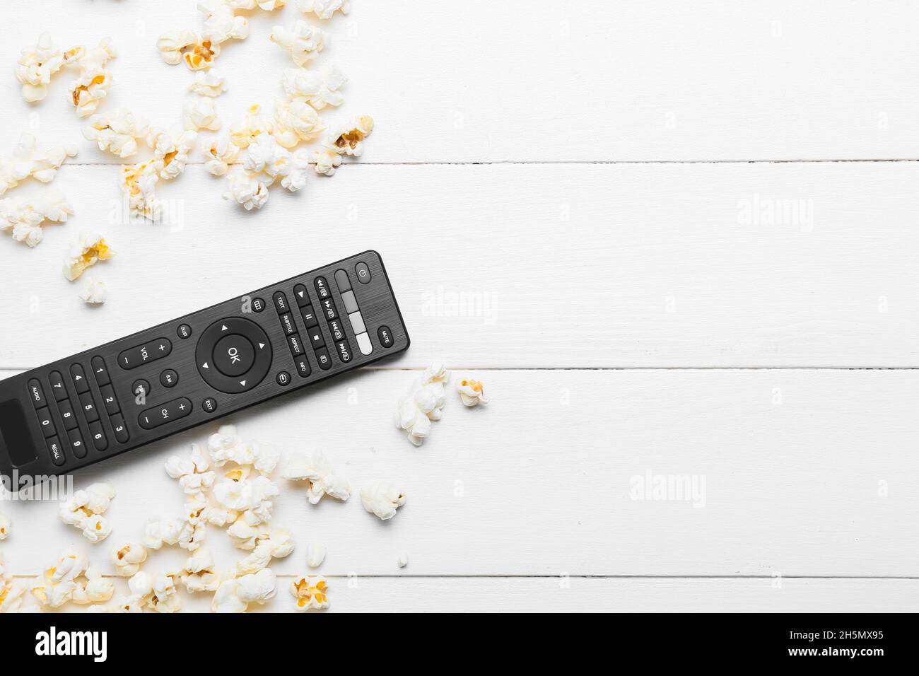 Modern TV remote control with popcorn on light wooden background Stock ...