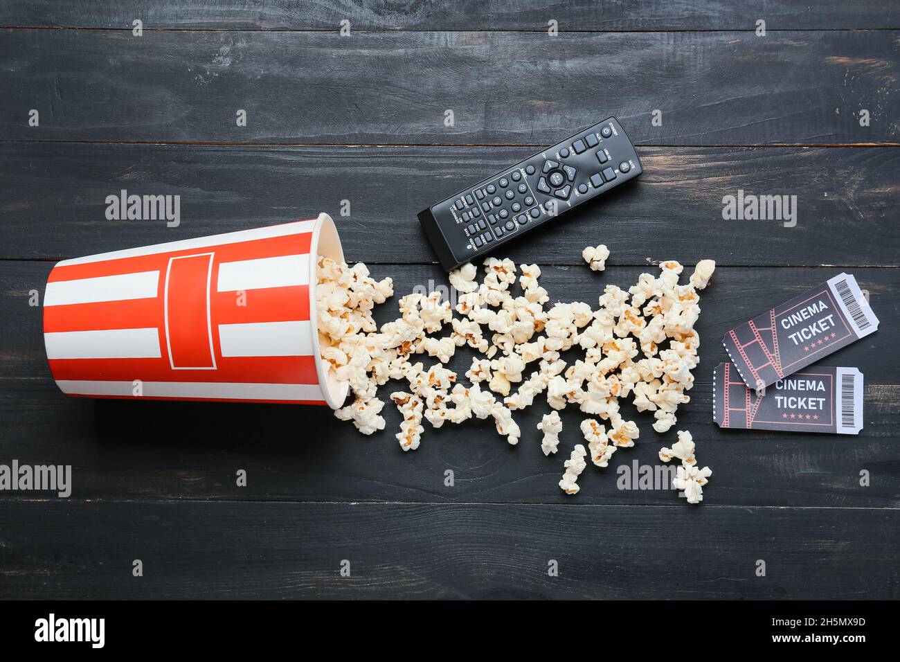 Modern TV remote control, bucket with popcorn and cinema tickets on ...
