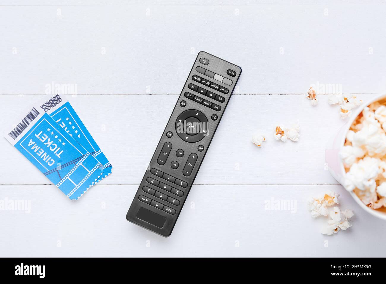 Modern TV remote control, bucket with popcorn and cinema tickets on ...