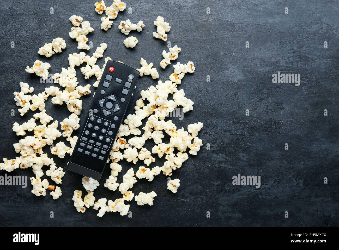 Modern TV remote control and popcorn on dark background Stock Photo - Alamy