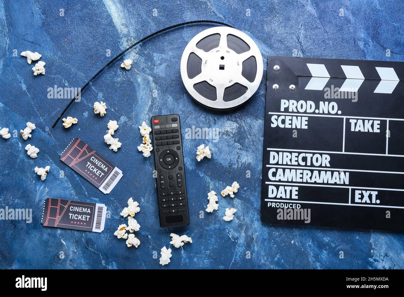 Modern TV remote control, film reel, clapperboard and cinema tickets on ...