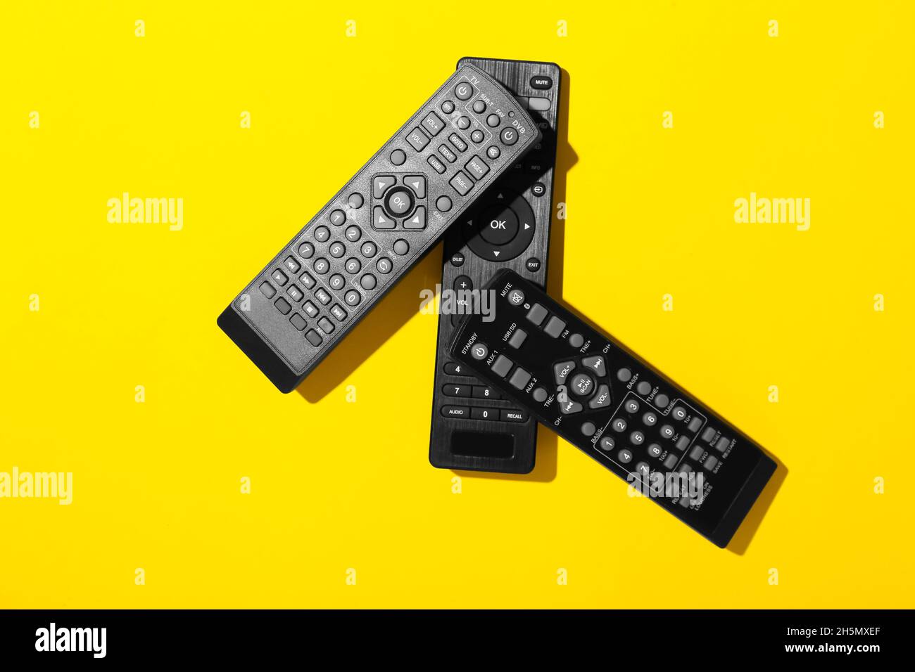 Different black TV remote controllers on yellow background Stock Photo ...