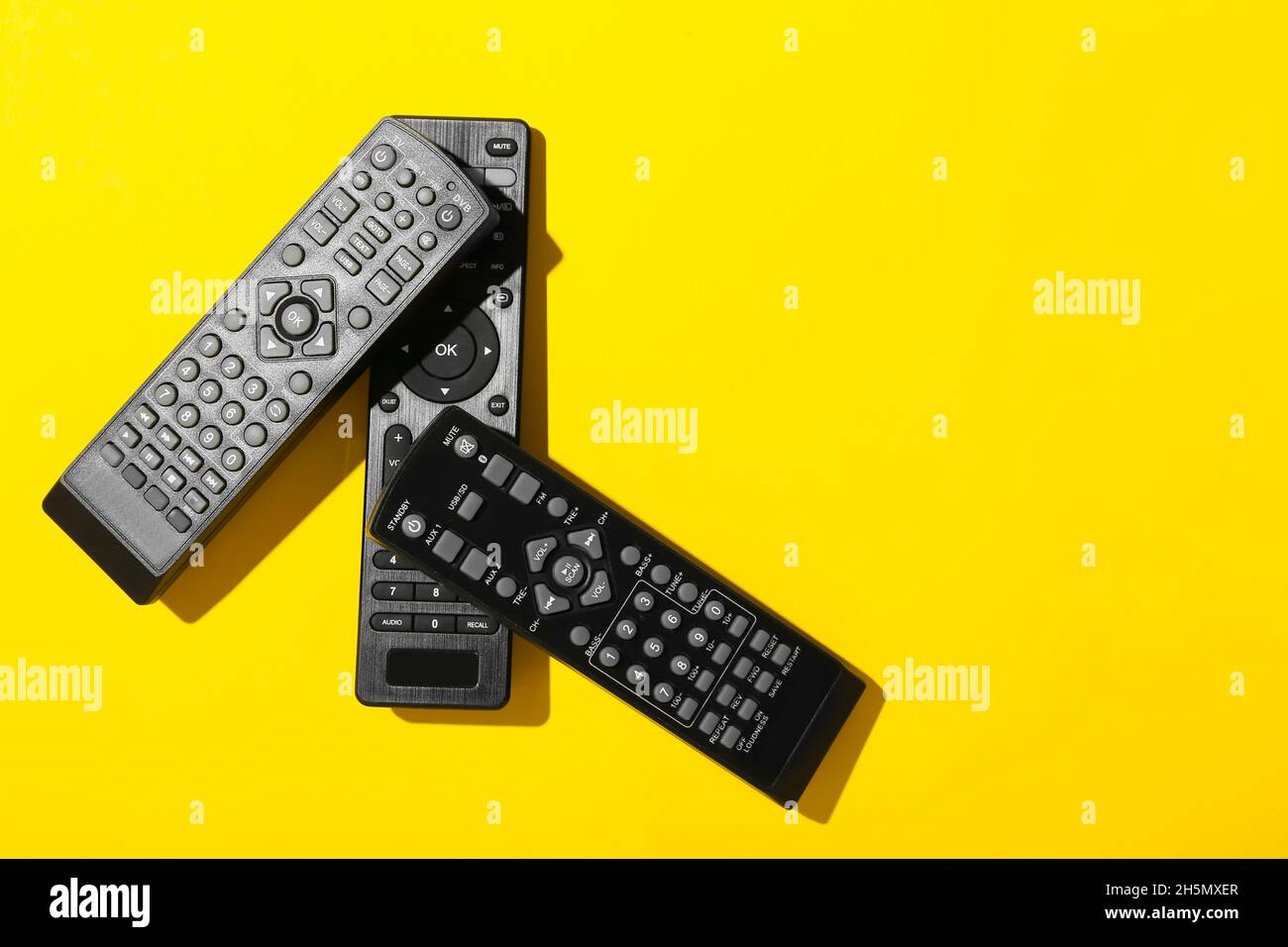 Different black TV remote controllers on yellow background Stock Photo ...