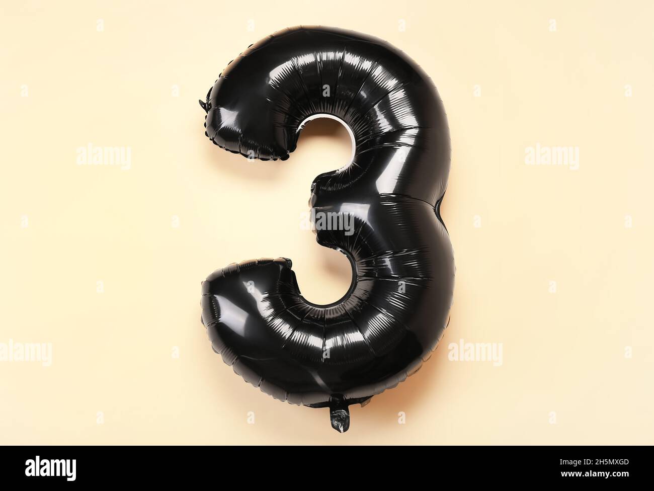Black balloon in shape of figure 3 on color background Stock Photo - Alamy