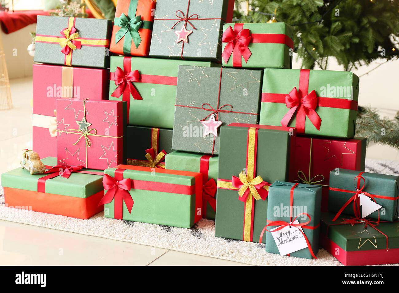 Many Christmas gift boxes on floor in room Stock Photo - Alamy