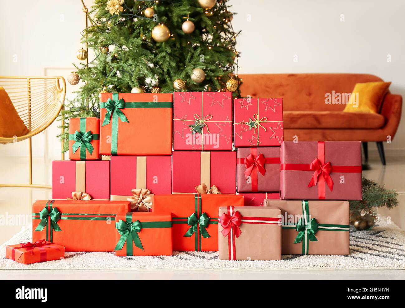 Many Christmas gift boxes on floor in room Stock Photo - Alamy