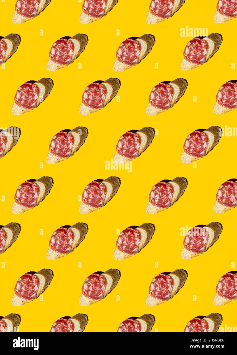 Pattern with salami sandwich on yellow background Stock Photo - Alamy