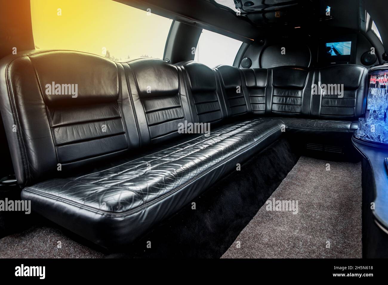 Luxury car interior limousine with black leather seats and a small bar ...