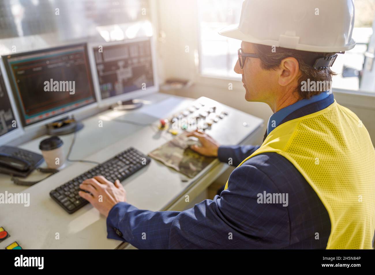 Male worker using computers at manufacturing plant Stock Photo - Alamy