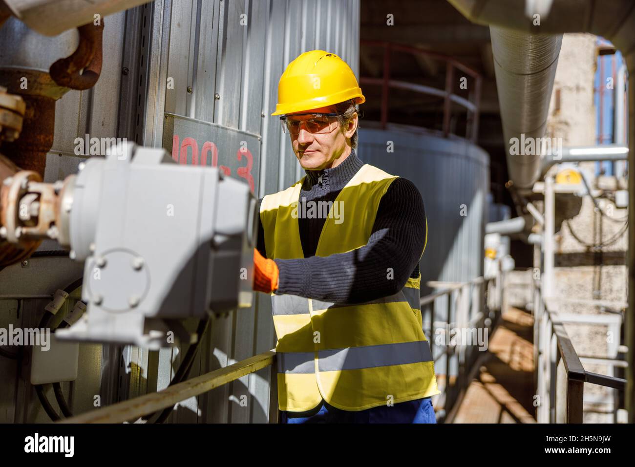 Male engineers in safety helmet working at factory Stock Photo - Alamy