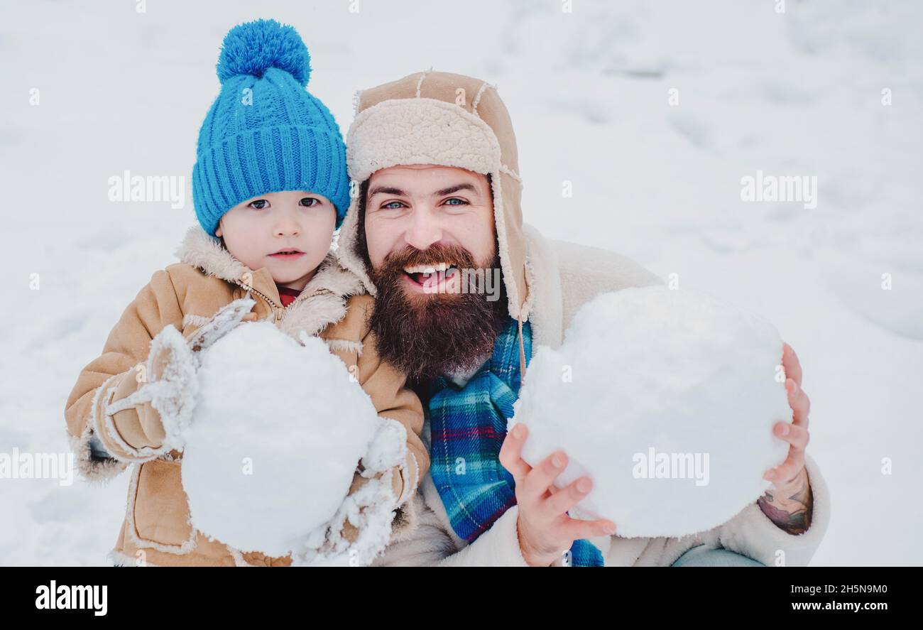 Winter, father and baby son play outdoor. Happy father and son making ...