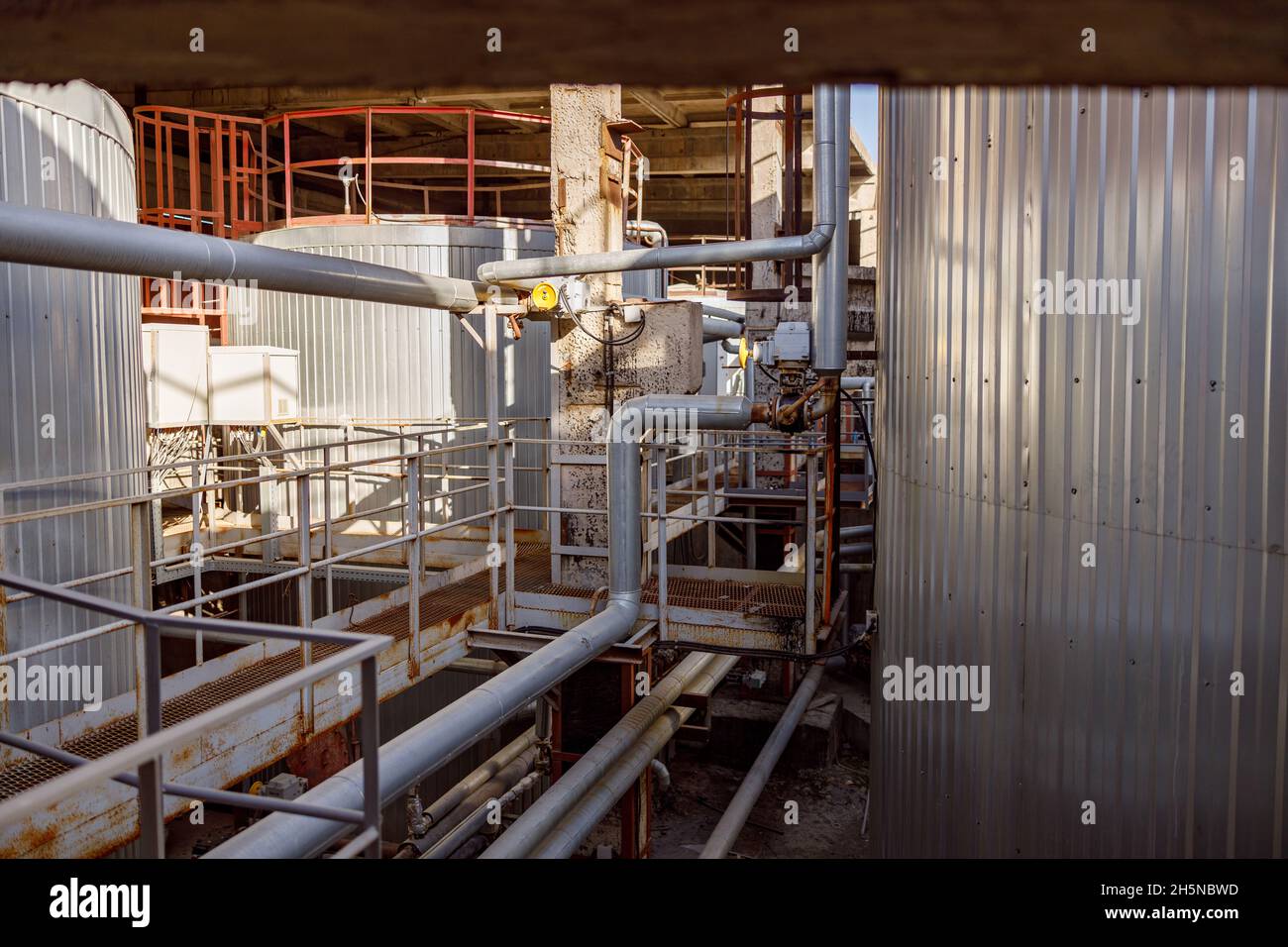 Pipes and steel storage containers at manufacturing plant Stock Photo ...