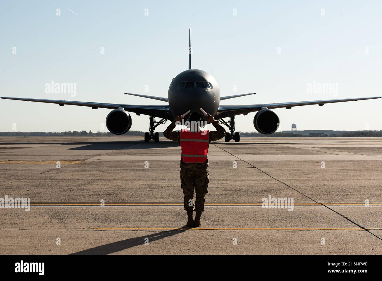 An airman assigned to 605th Maintenance Squadron marshals in a KC-46A ...
