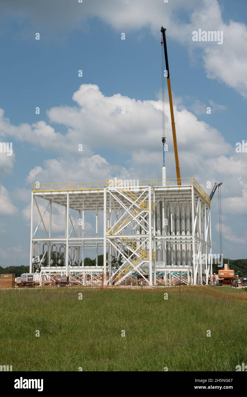 A high-pressure air (HPA) bottle is lifted and lowered into place in ...