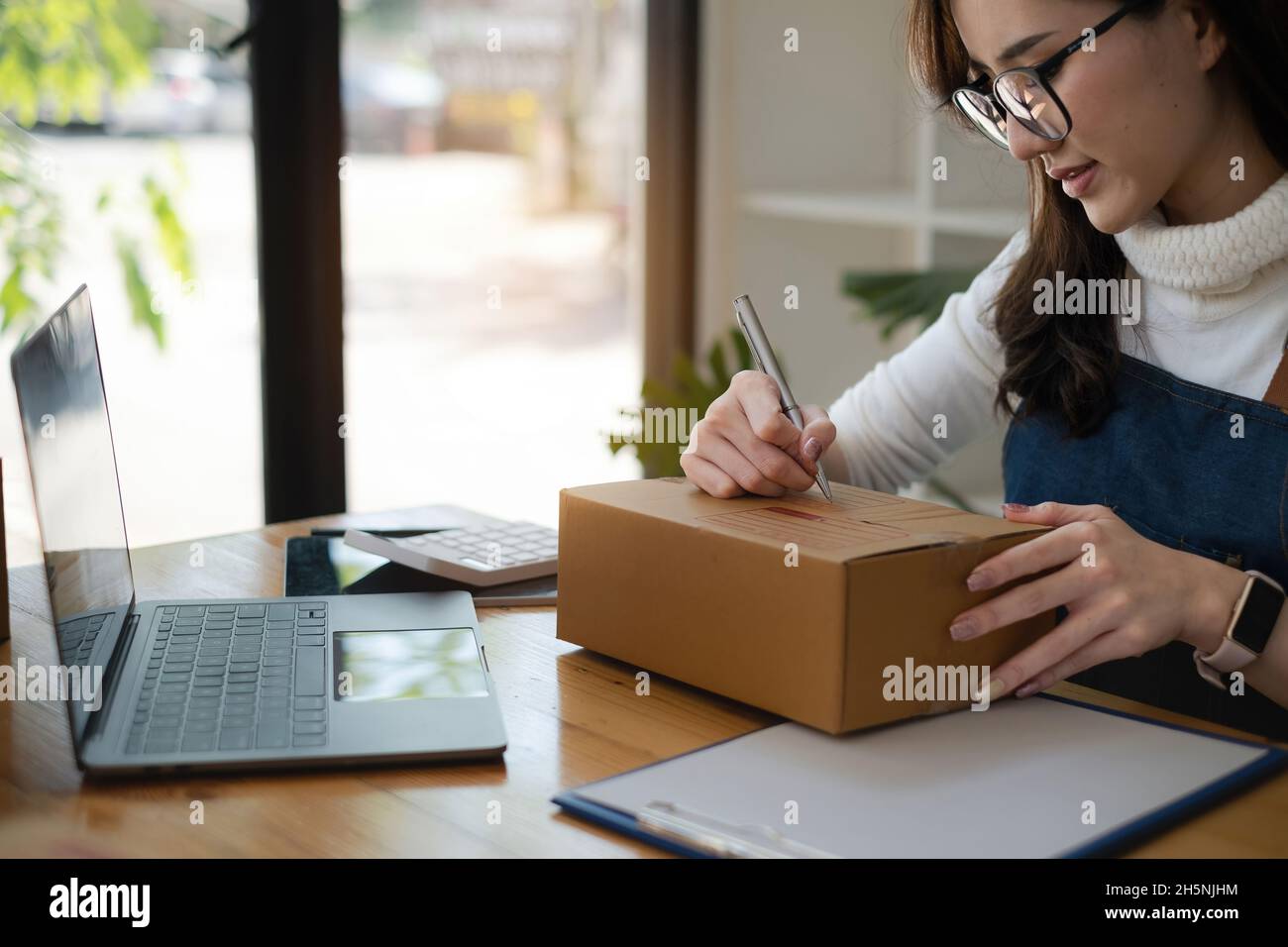Business owner writing address before send to customer. Successful SME ...