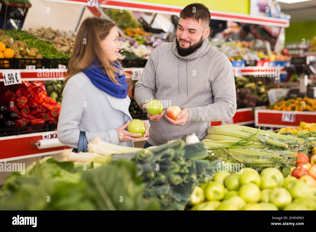 Glad couple choosing vegetables in grocery shop Stock Photo - Alamy