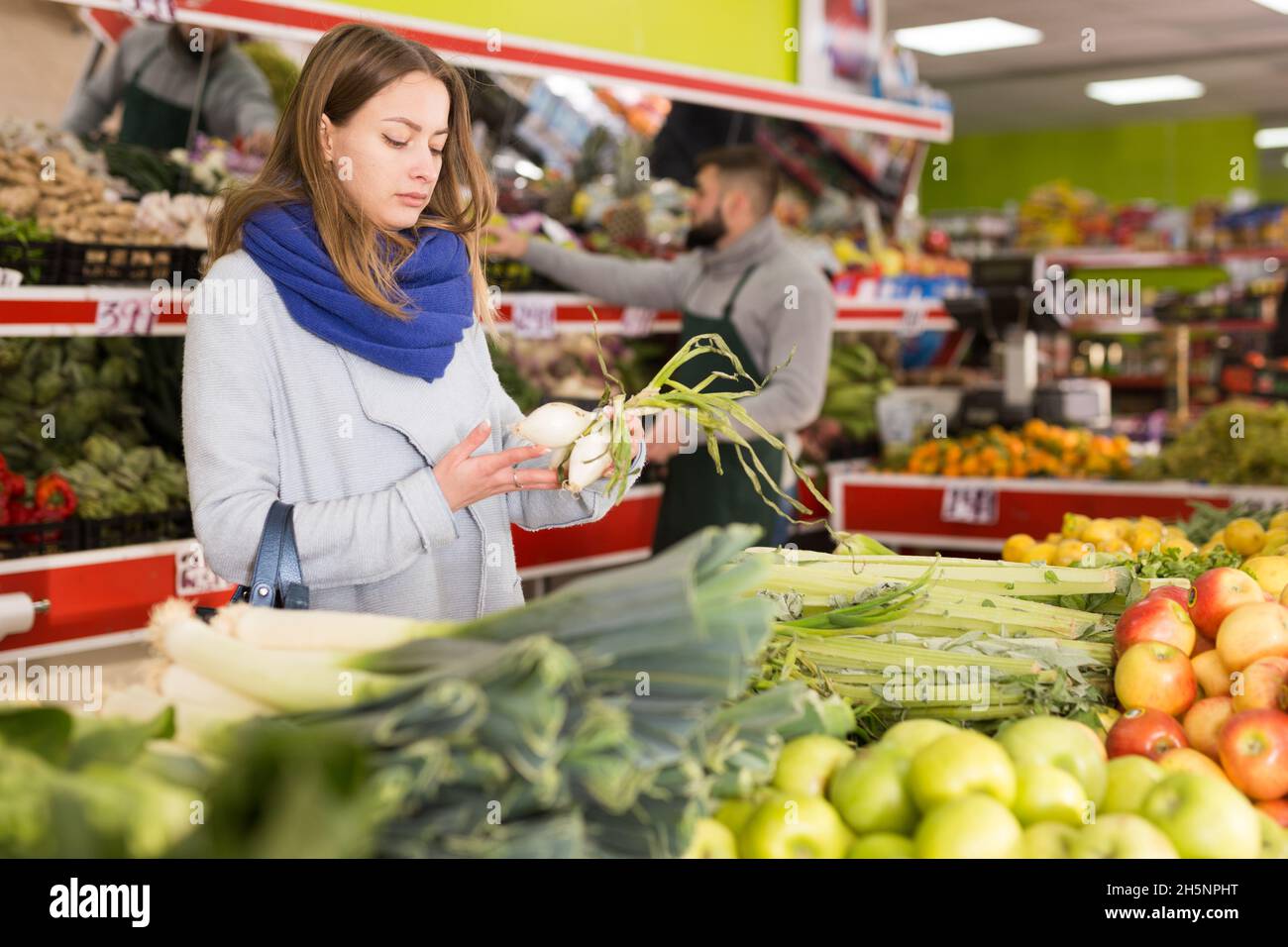 Female shopper picks onions at grocery store Stock Photo - Alamy
