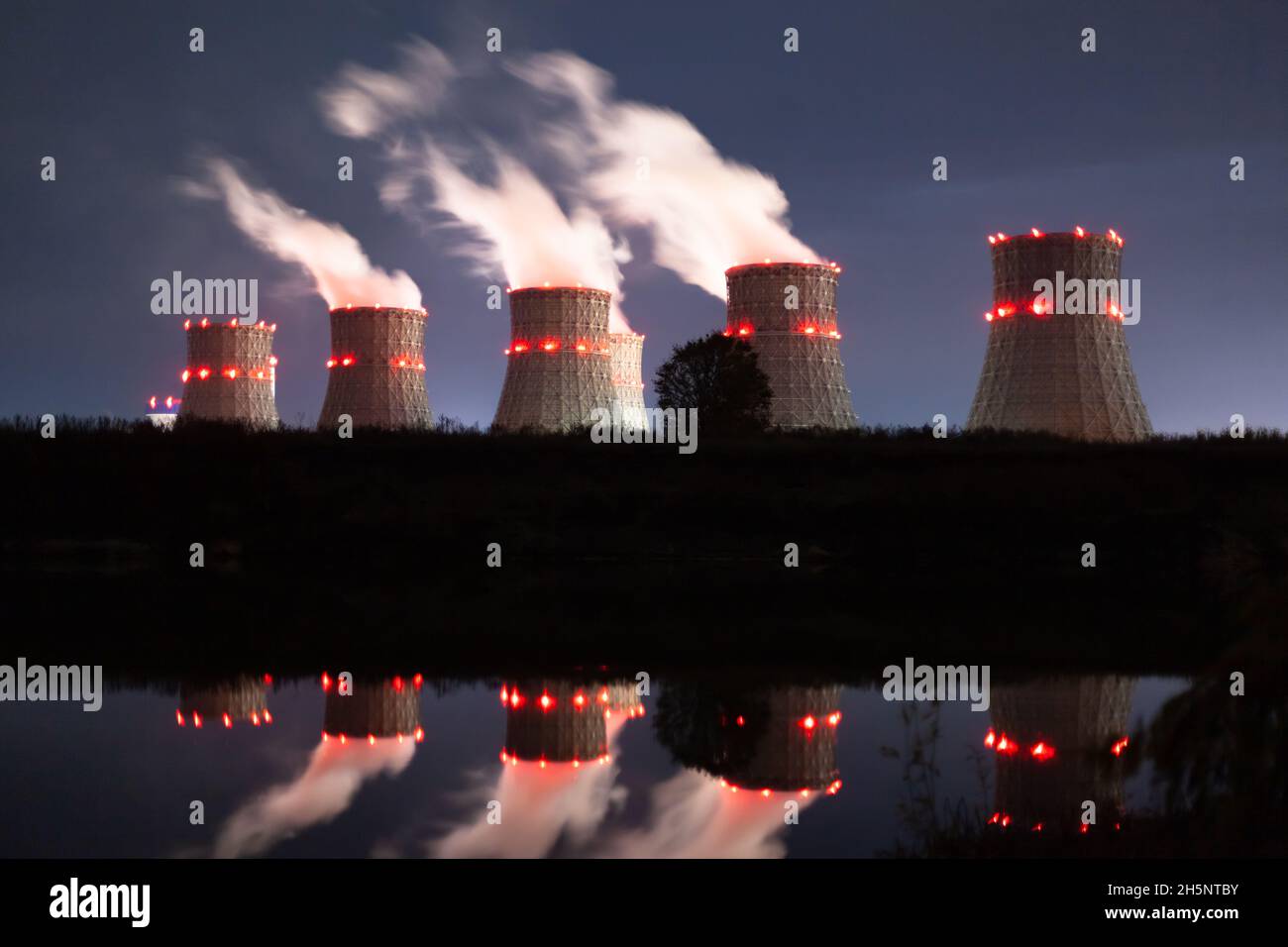 The lights of a nuclear power plant are reflected in a pond. Nuclear ...