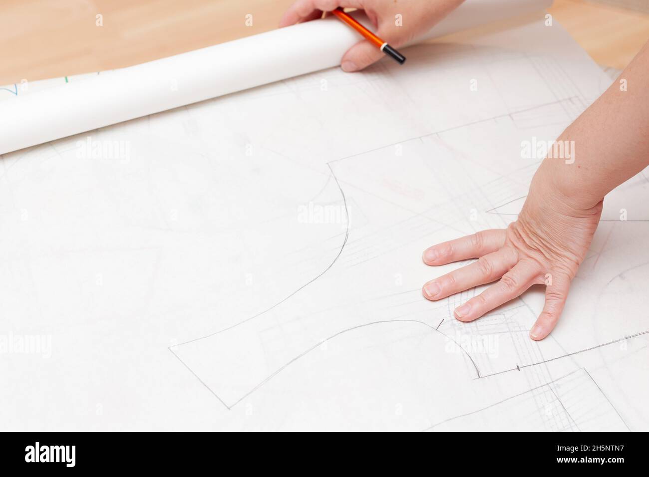 Female designer drawing flat paper patterns. Exclusive clothes making ...