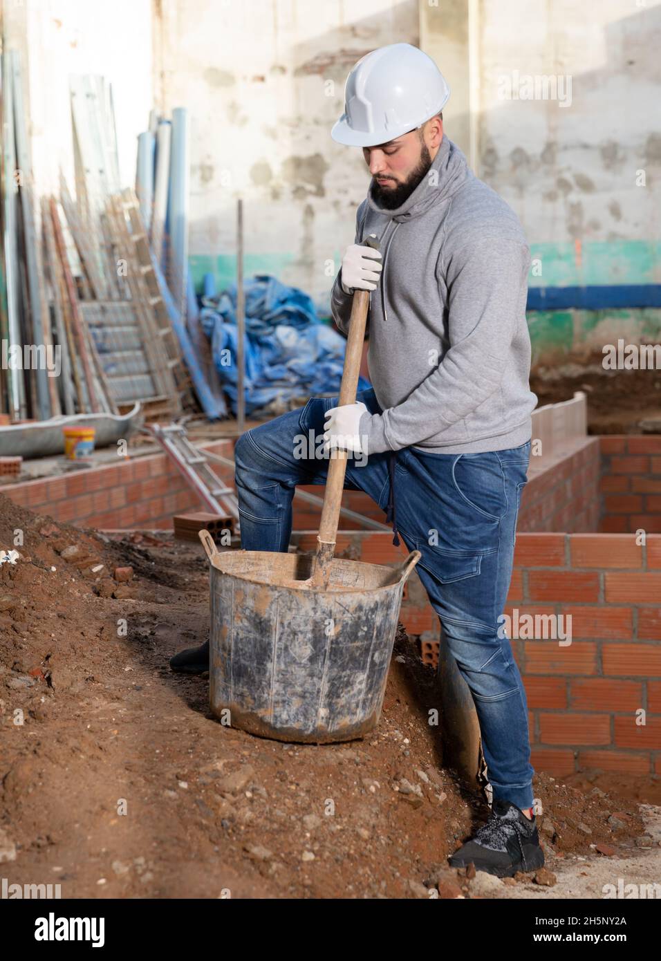 Man kneading construction mortar Stock Photo - Alamy