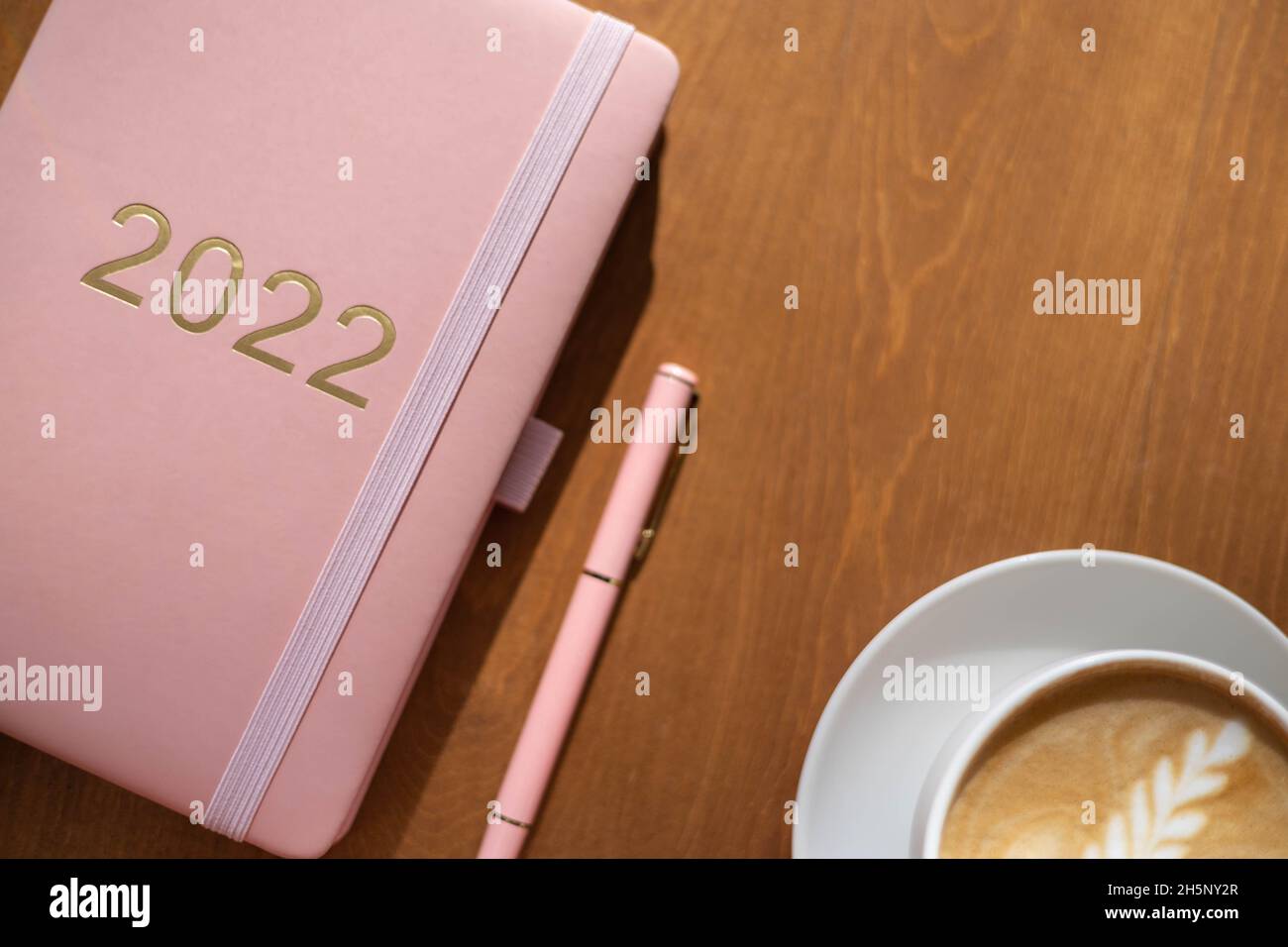 Pink coral colored diary for the year 2022, pen, coffee Stock Photo - Alamy