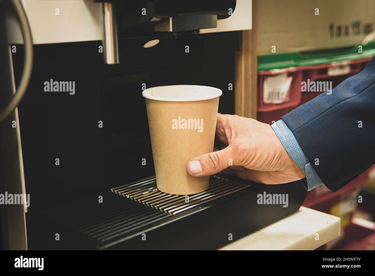 man takes coffee from a vending machine. cropped view of businessman ...