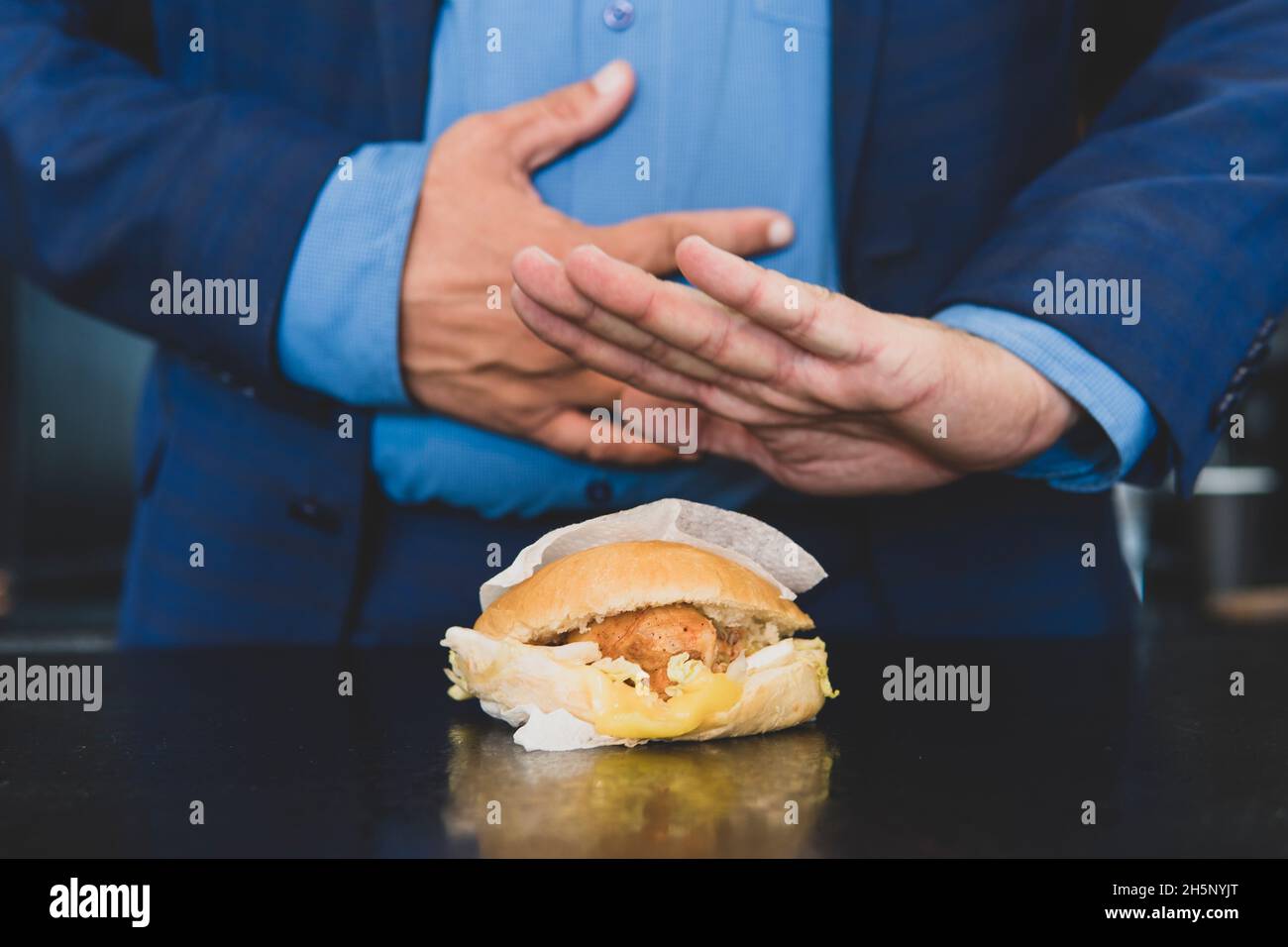 Businessman having stomachache because of eating junk food. A man who ...