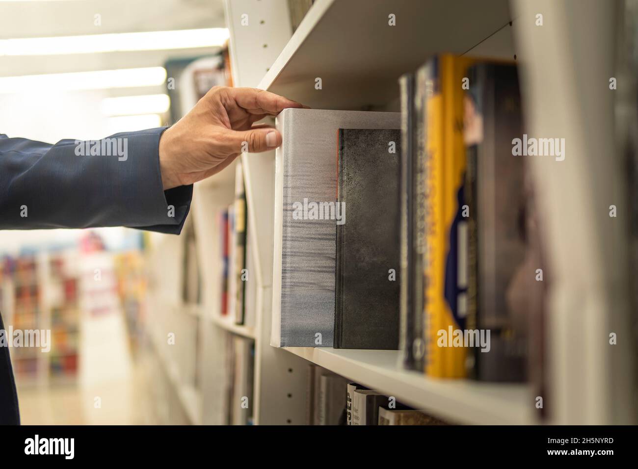 student in book shop or library. man chooses literature in a bookstore ...