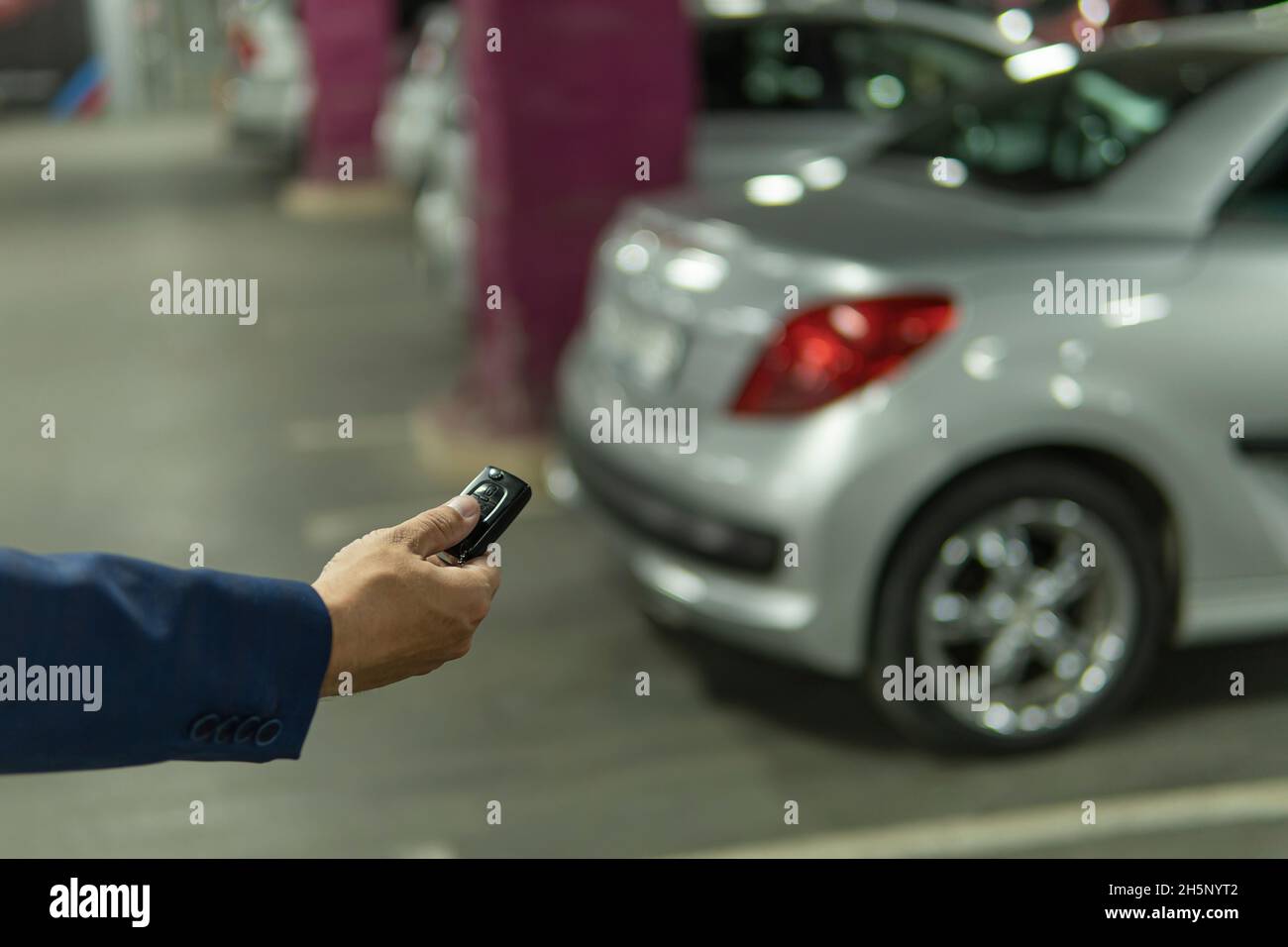 Close up hand a man Press the button of car keys remote for lock and ...