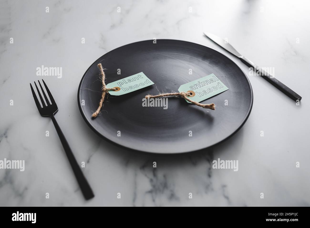 plant-based and animal-based product tags on top of black dining plate ...