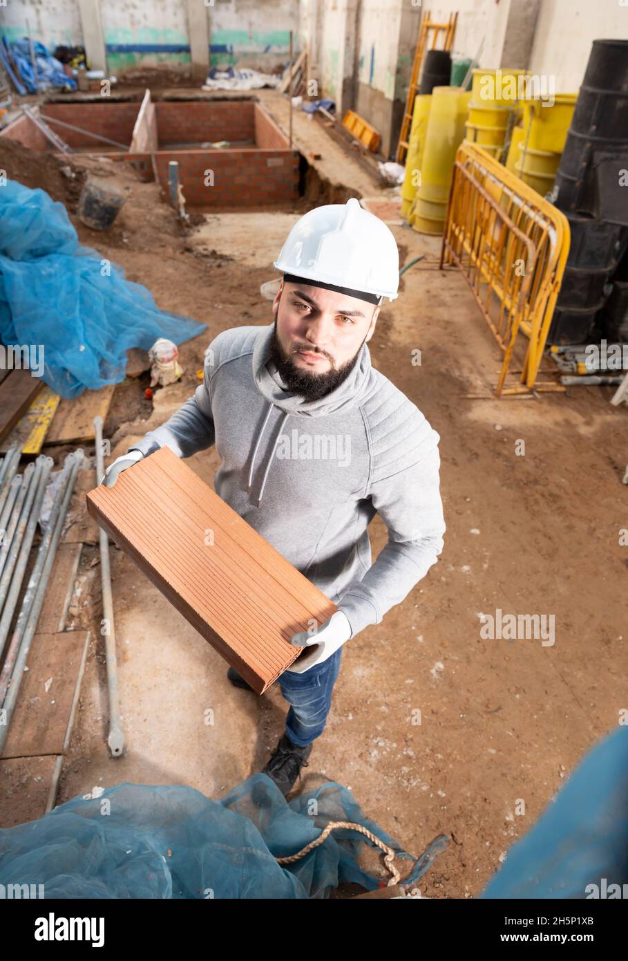 Builder working with red brick Stock Photo - Alamy