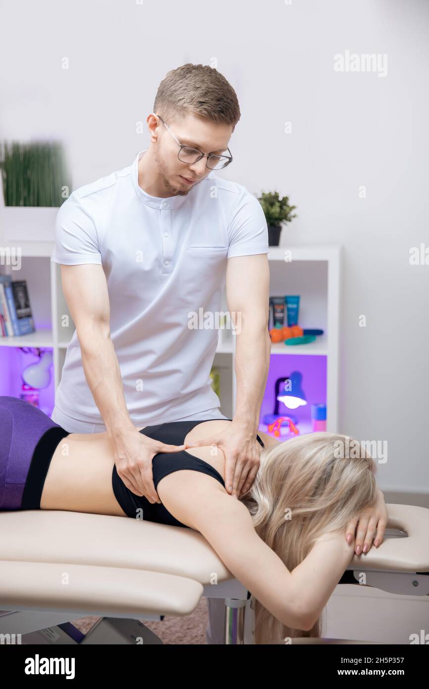 Osteopath performs back massage young hi-res stock photography and ...