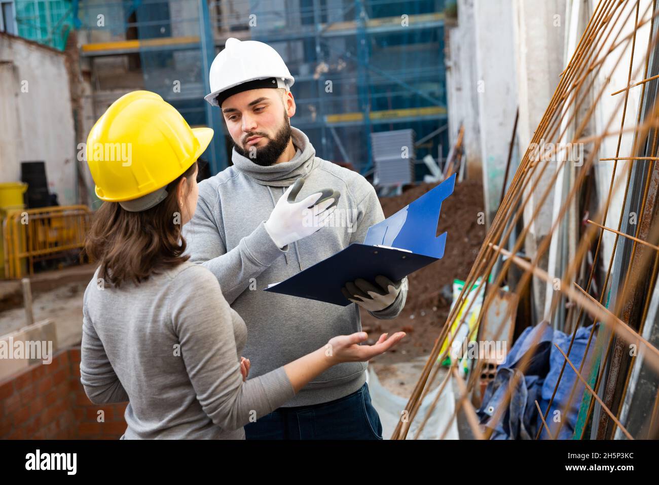 Engineers discussing blueprint at construction site Stock Photo - Alamy