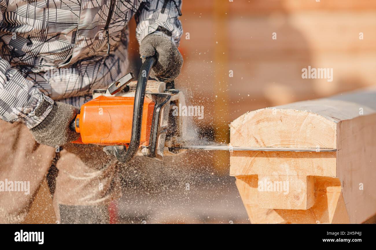 Industrial work carpenter sawing with chainsaw log, construction frame ...
