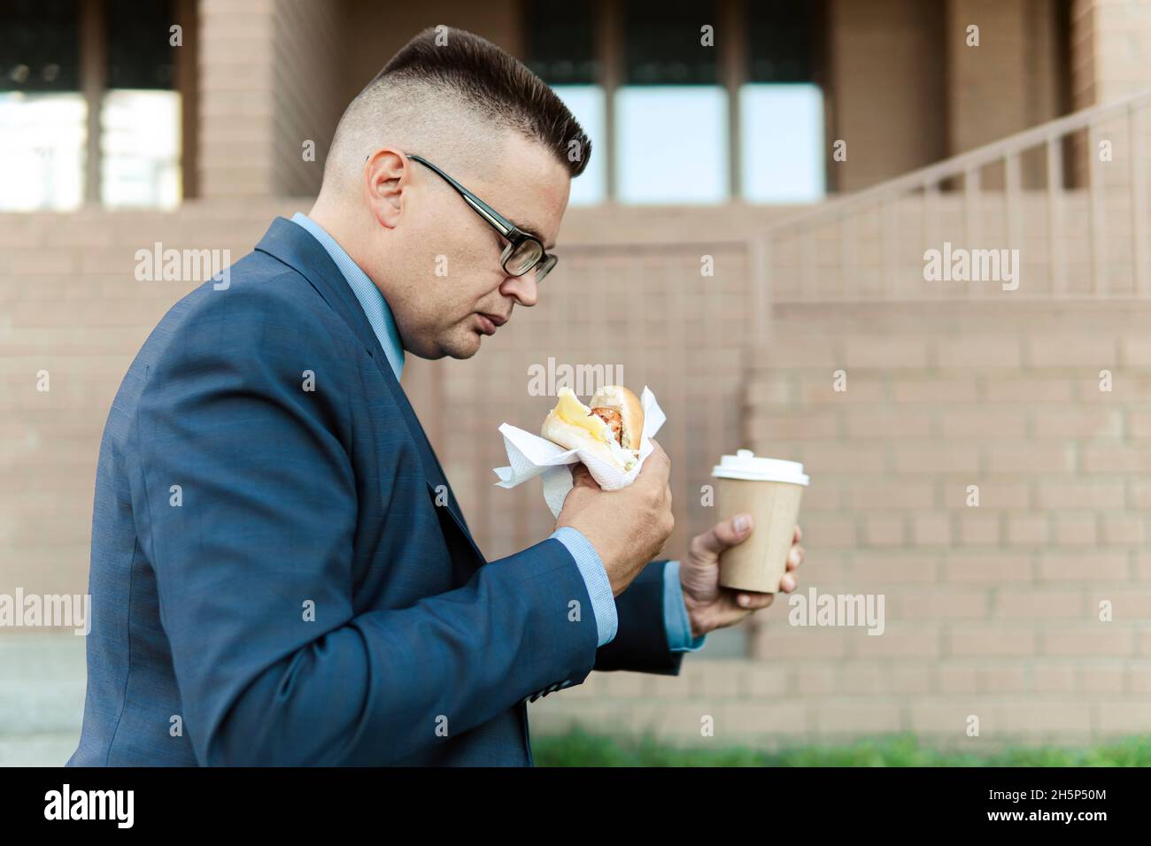 Business man eating snack walking hi-res stock photography and images ...