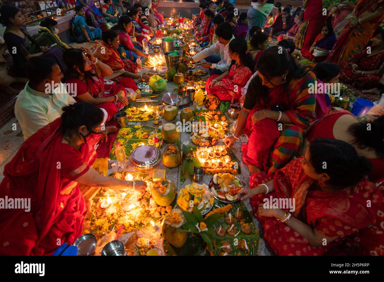Hindu devotees sit with Prodip (lights) and pray to God for the welfare ...