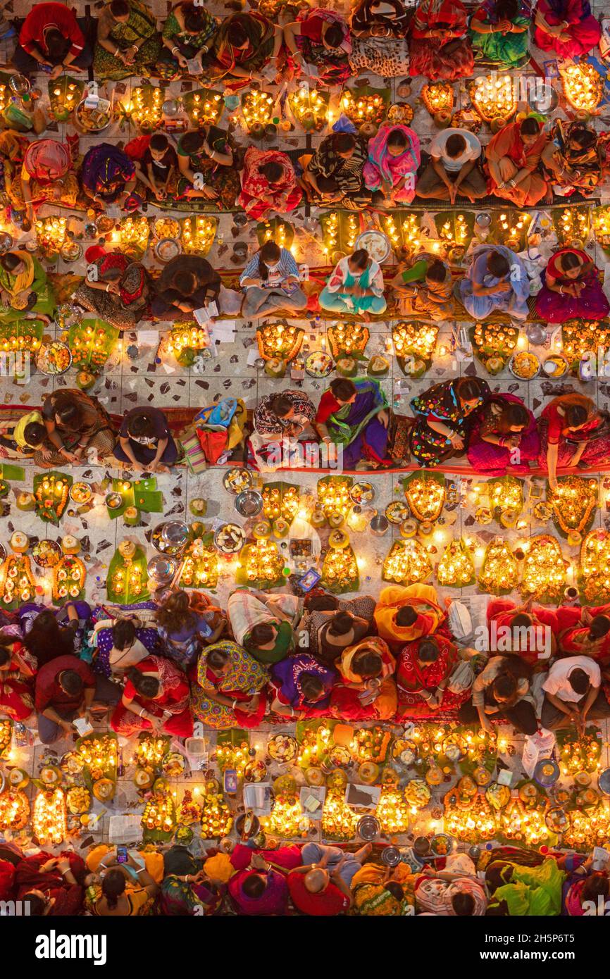 Hindu devotees sit with Prodip (lights) and pray to God for the welfare ...